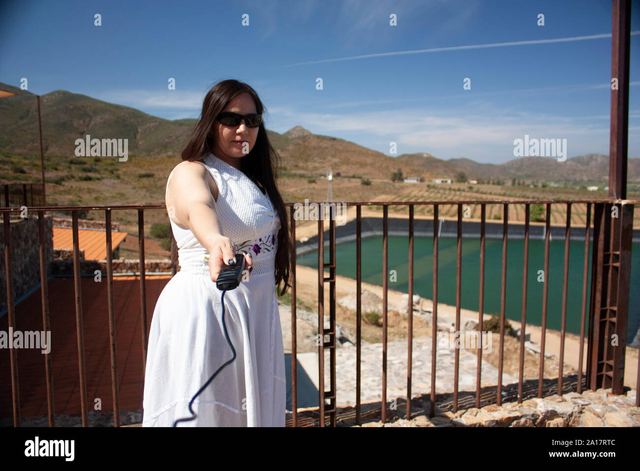 Woman standing in front of camera sharing scene with rural landscape of ...