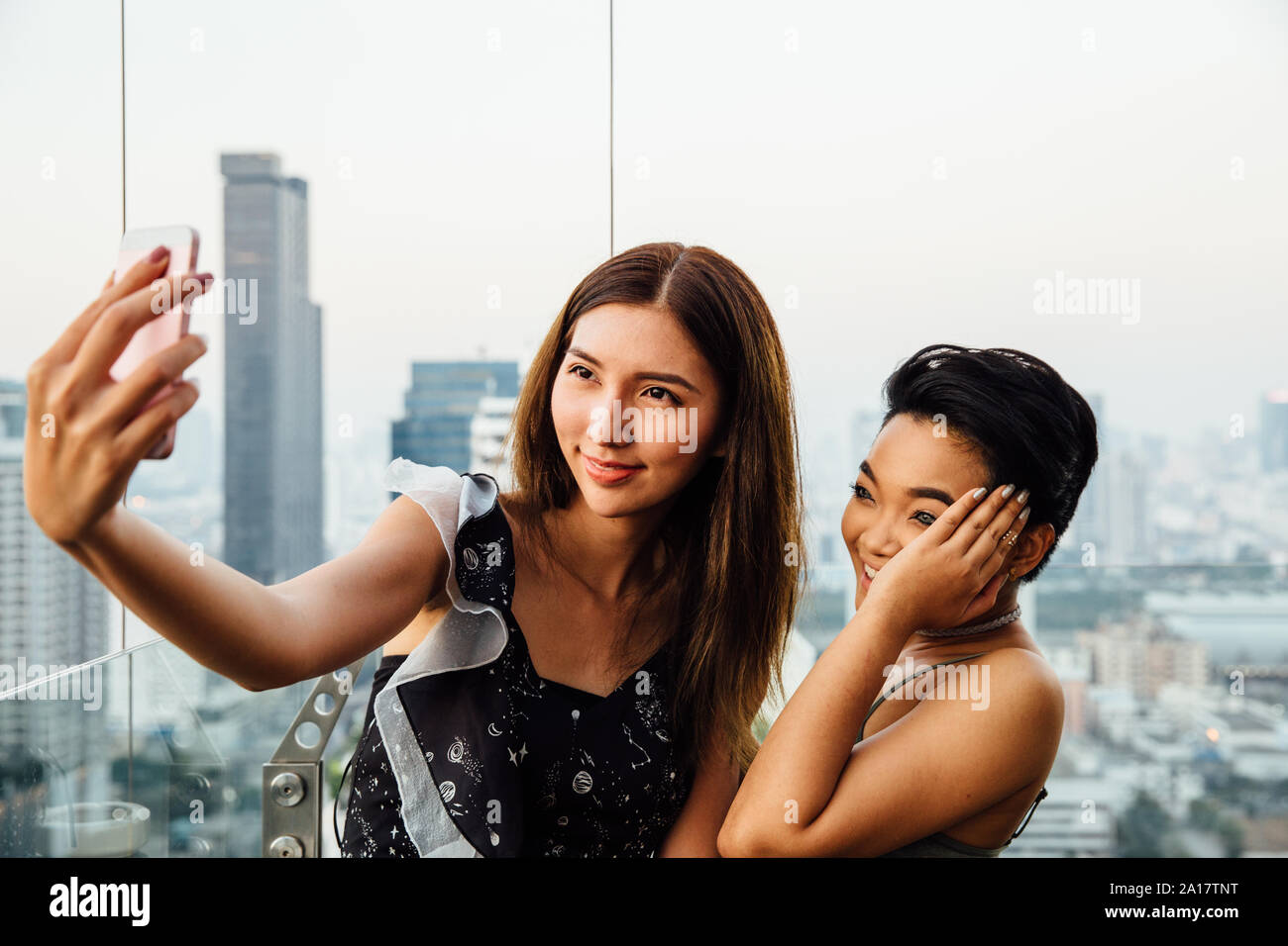 Two women talking selfie on top of a large urban building Stock Photo ...