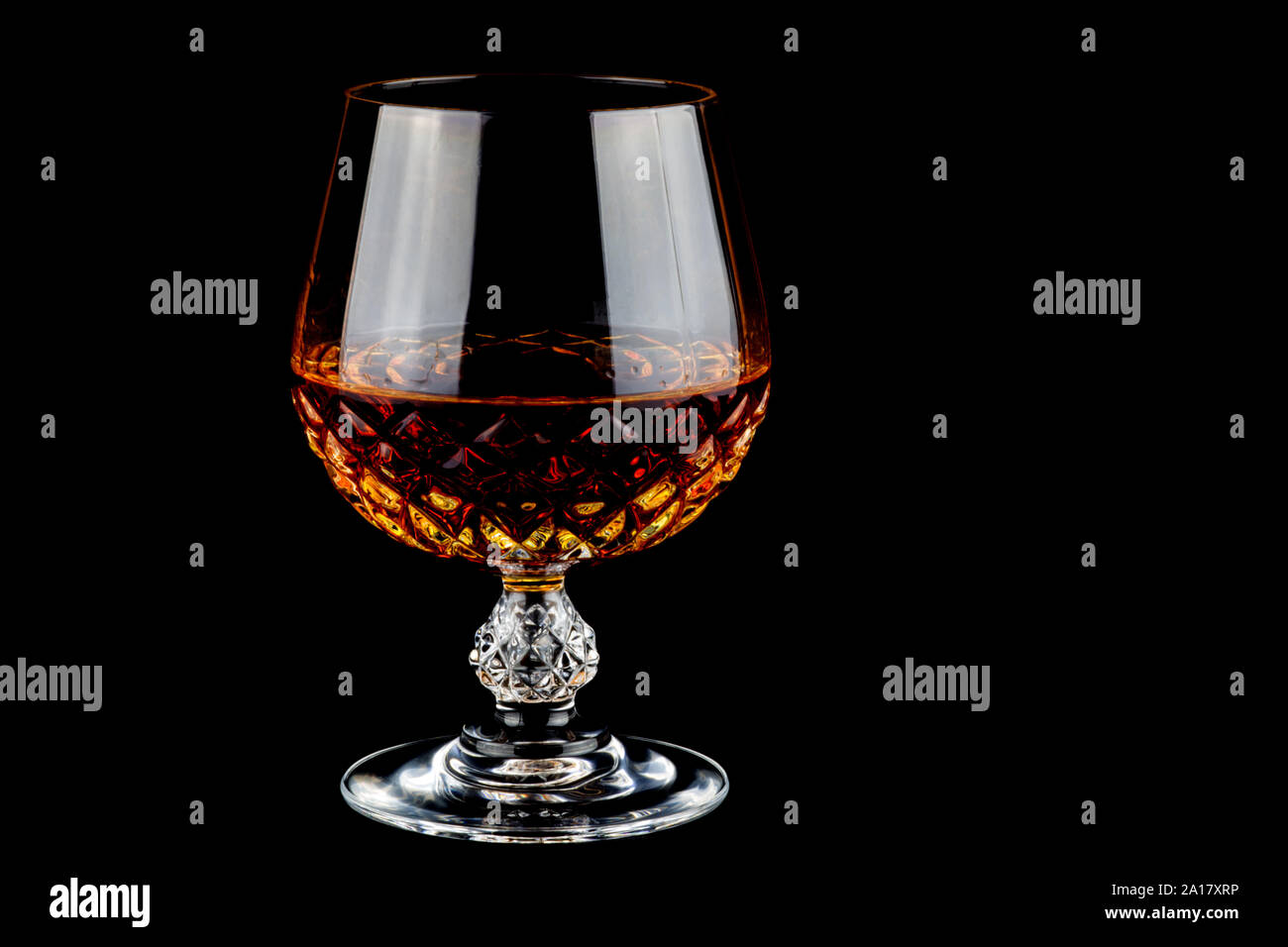 Brandy in a crystal glass isolated against a black background Stock ...