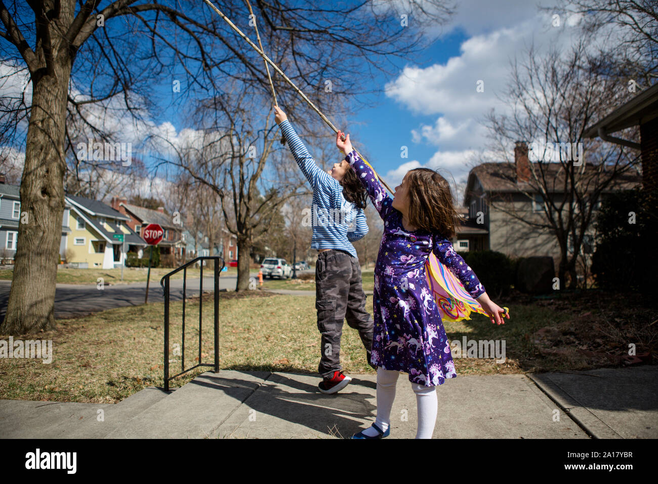 Two happy children play with sticks on their front stoop Stock Photo ...