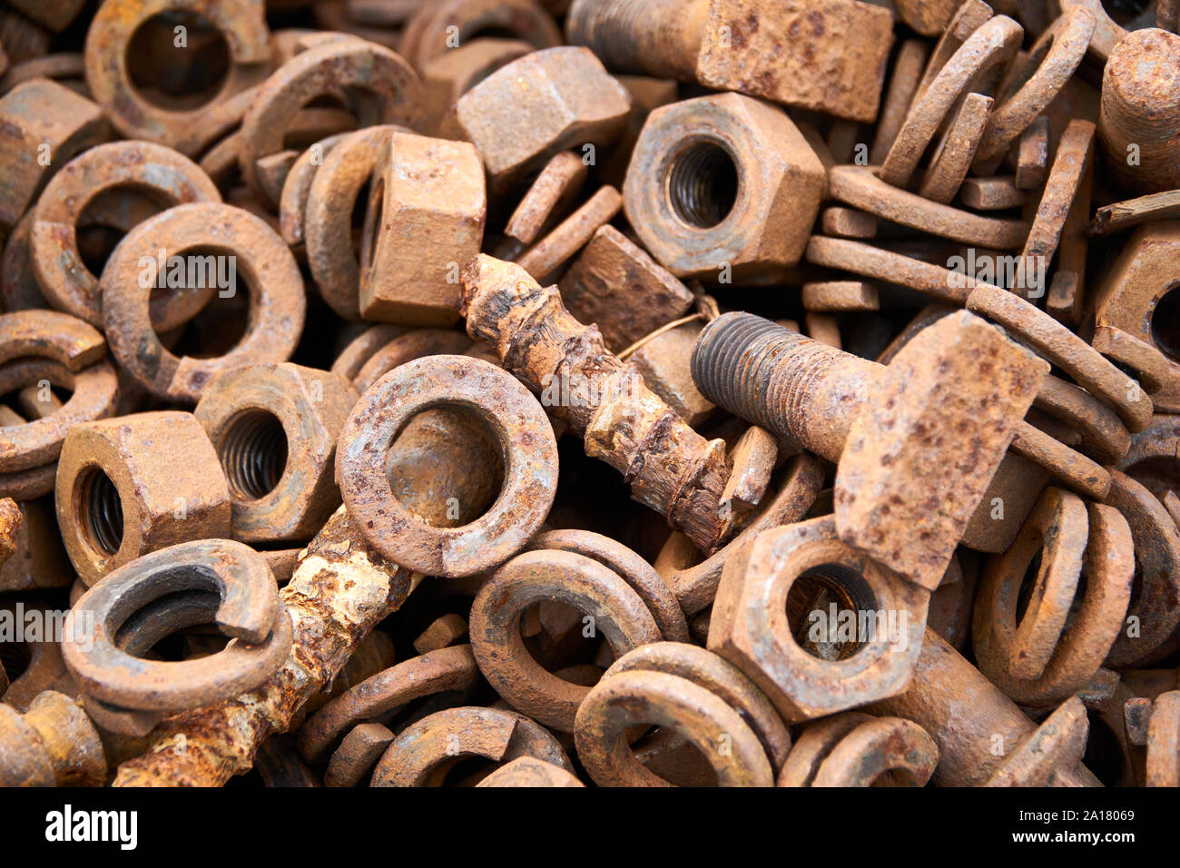 A pile of old and rusty screws, bolts, studs and nuts close to ...