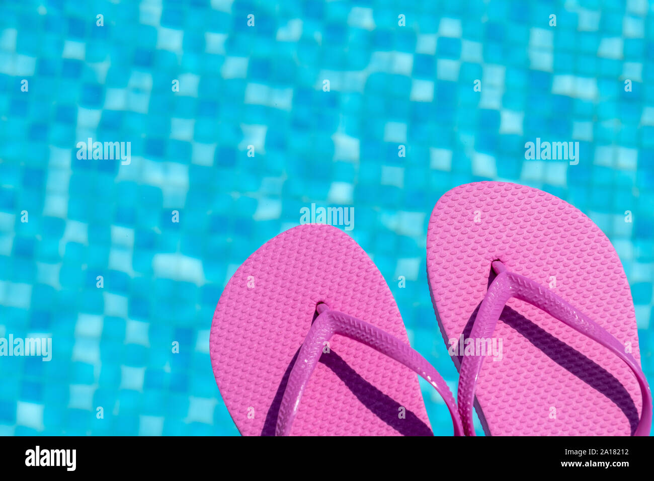 Pink flip flops over a swimming pool background Stock Photo - Alamy