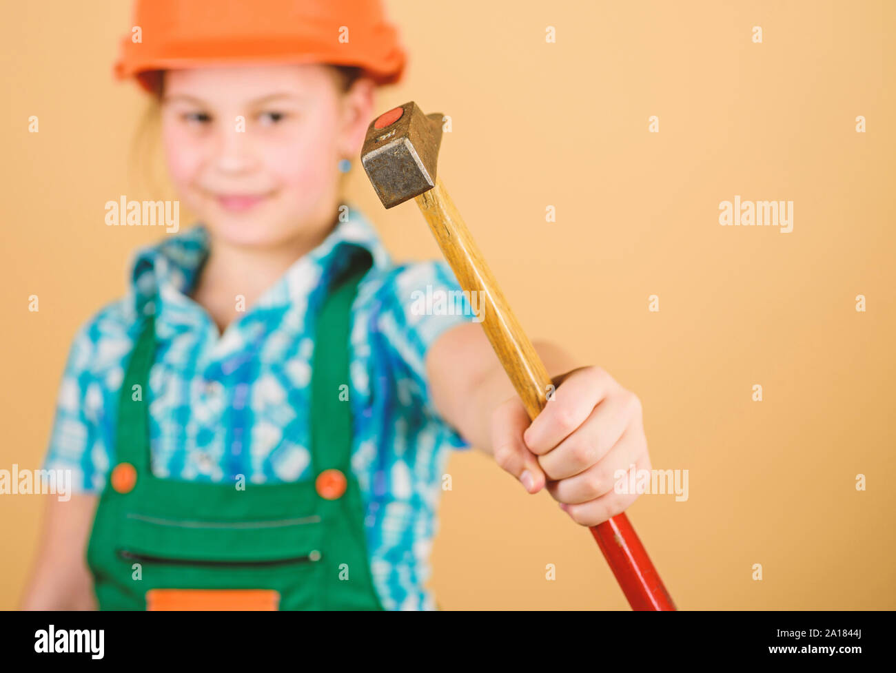 hammer in hand of small girl repairing in workshop. Foreman inspector ...