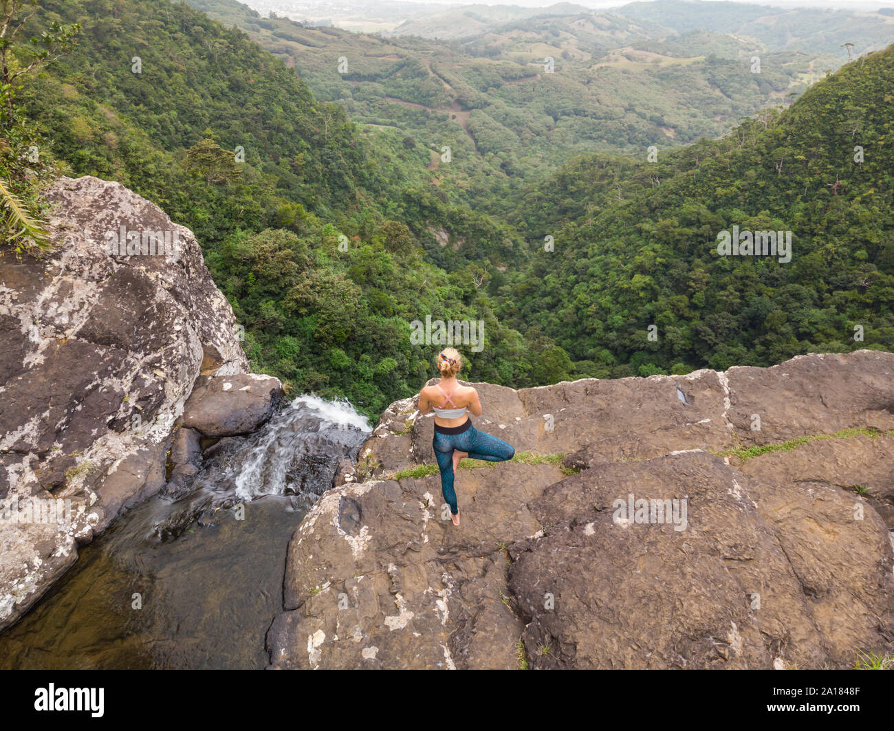 Active sporty woman relaxing in nature, practicing yoga on high clif by ...