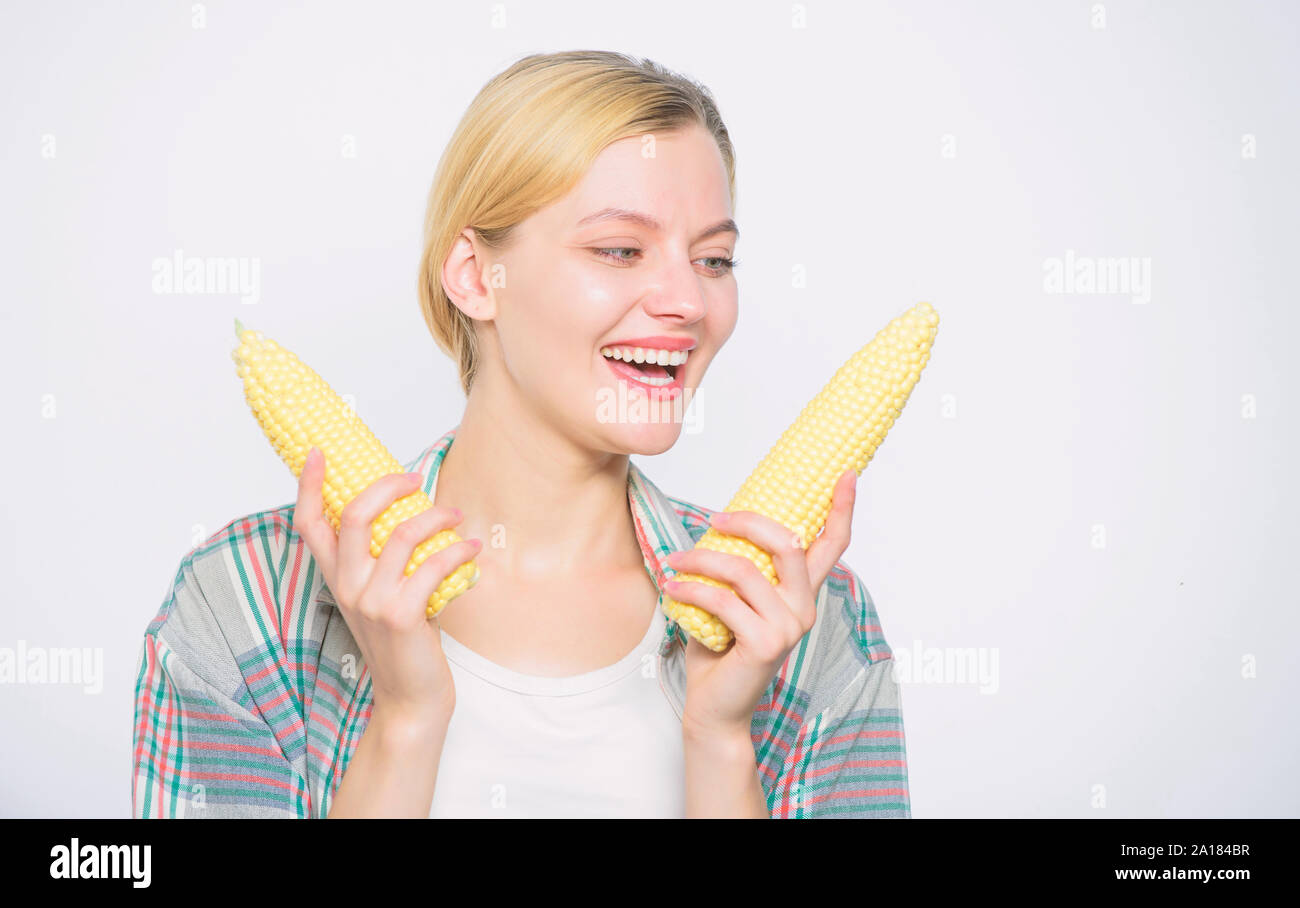 maize production. Farming, farmer girl with maize. Happy woman eating ...