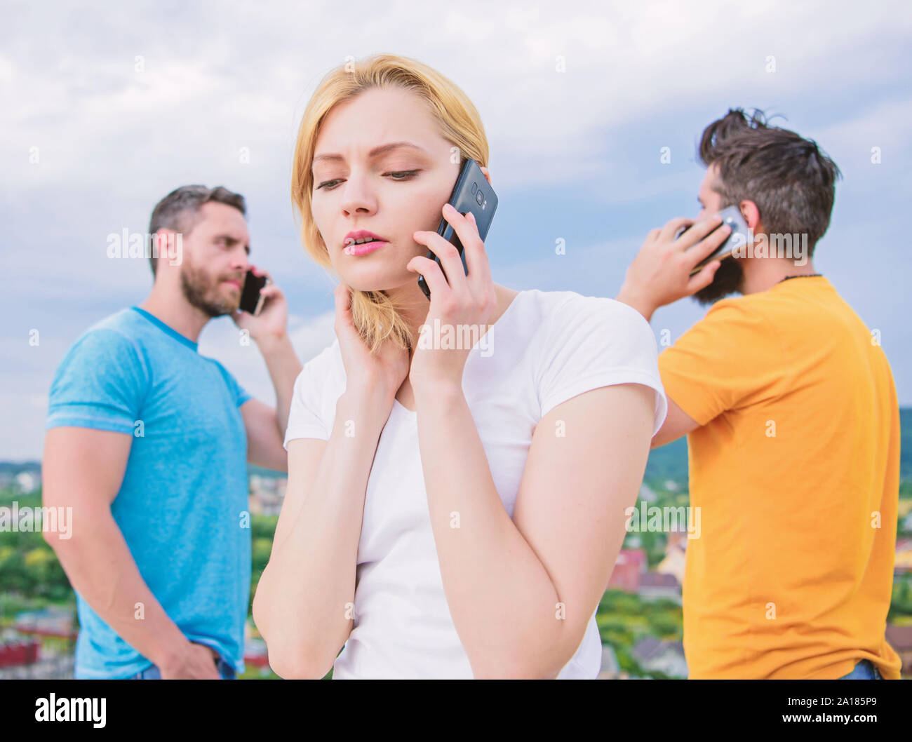 Using the mobile technology while on the move. Group of friends talk on ...