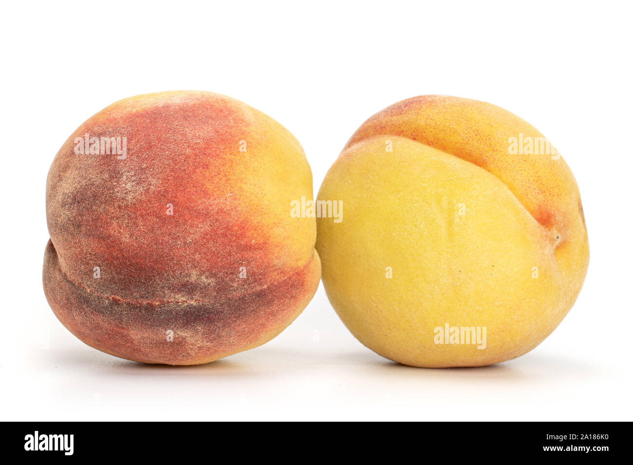 Group of two whole fresh fuzzy peach with blush isolated on white ...