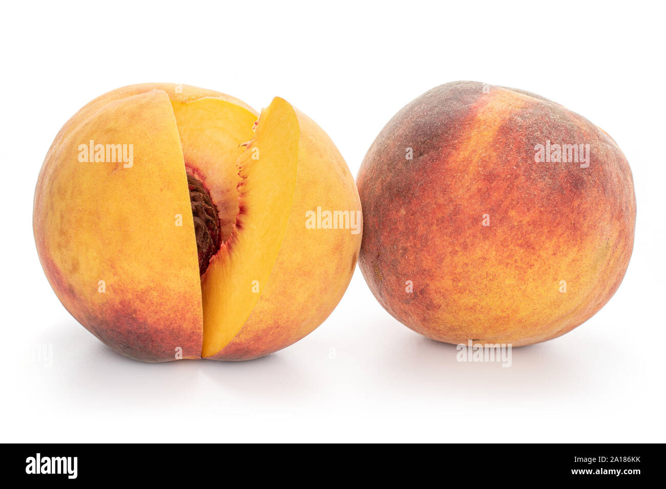 Group of two whole fresh fuzzy peaches one sliced isolated on white ...