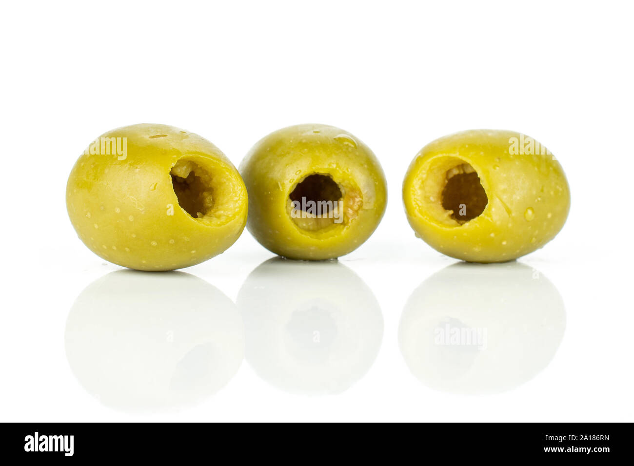 Group of three whole small pitted green olive isolated on white ...