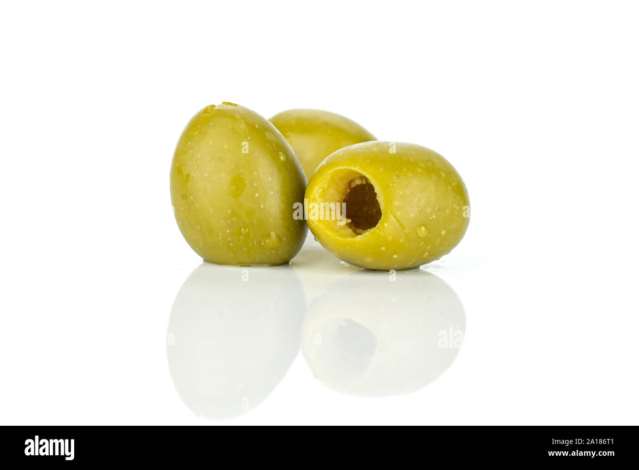 Group of three whole small pitted green olive isolated on white ...