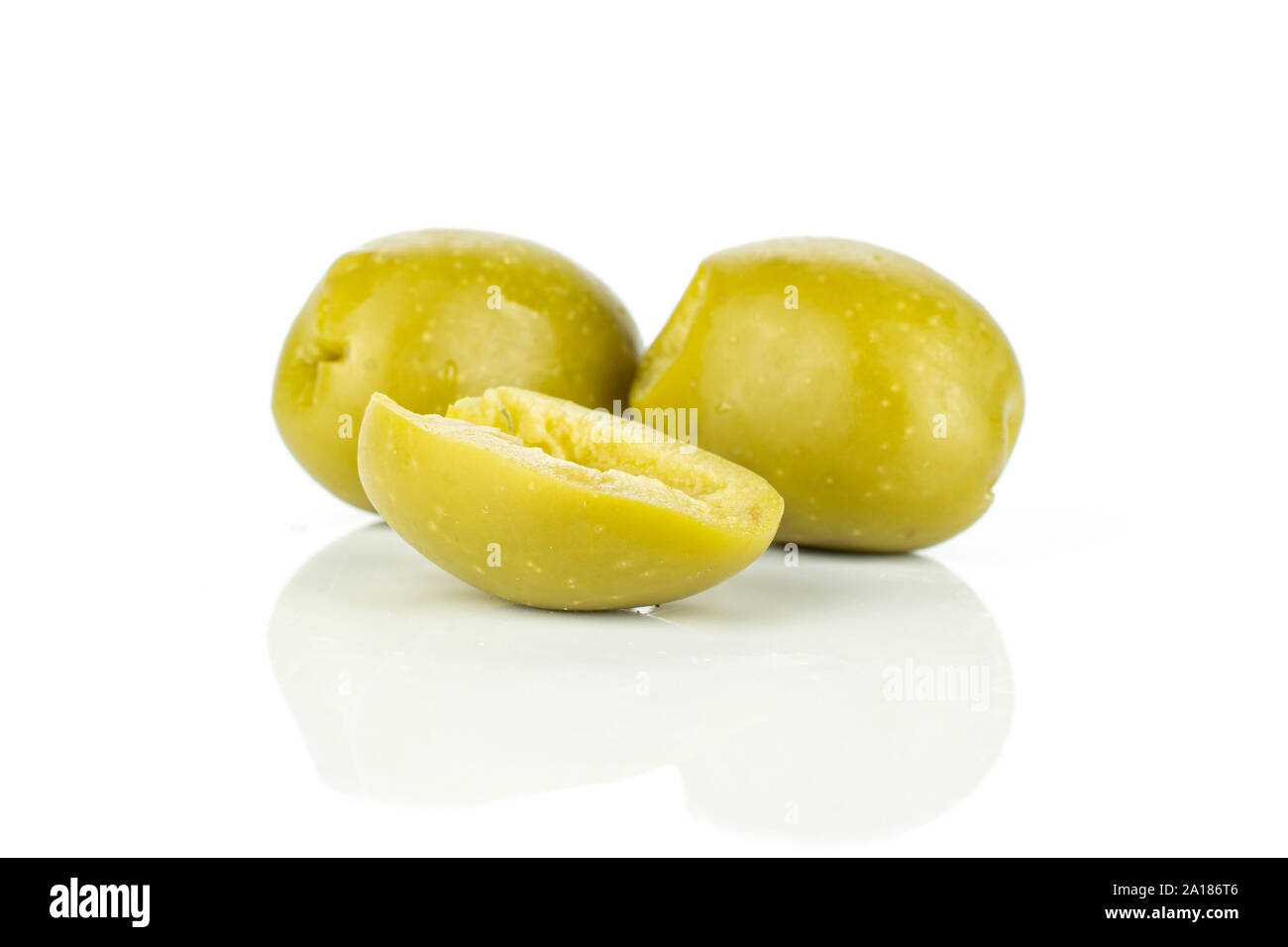 Group of two whole one half of pitted green olive isolated on white ...