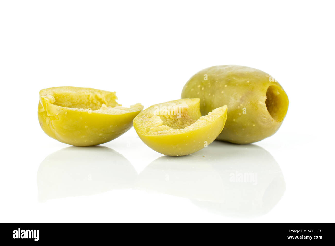 Group of one whole two halves of pitted green olive isolated on white ...
