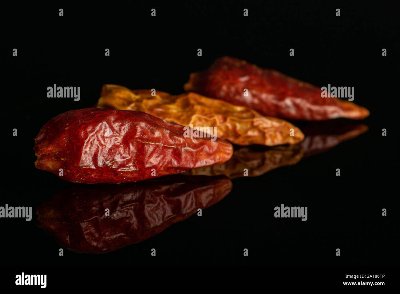 Group of three whole dry red chili pepper peperoncino in row isolated ...
