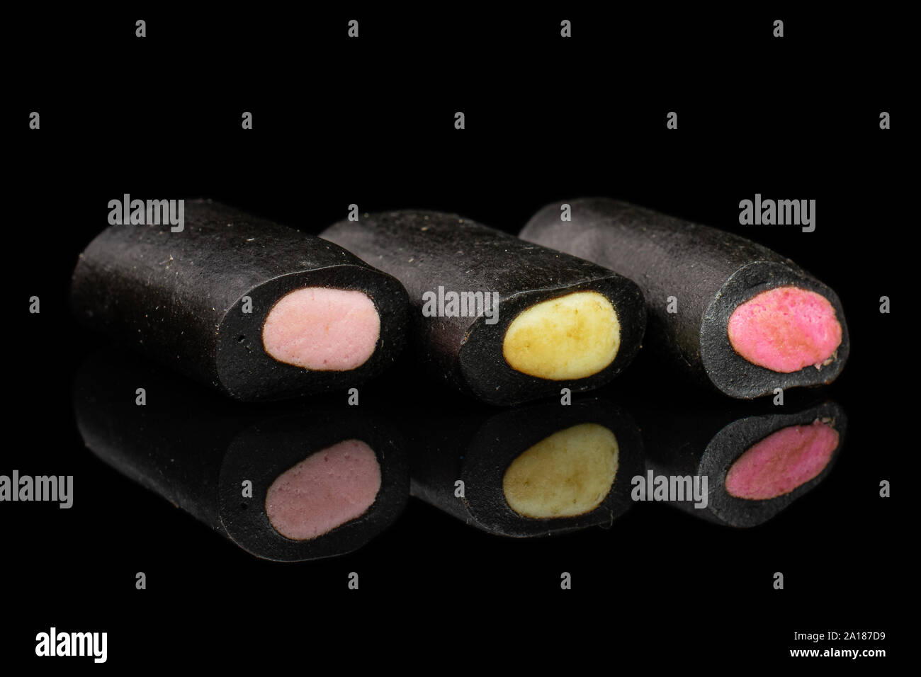 Group of three whole sweet black liquorice candy isolated on black ...