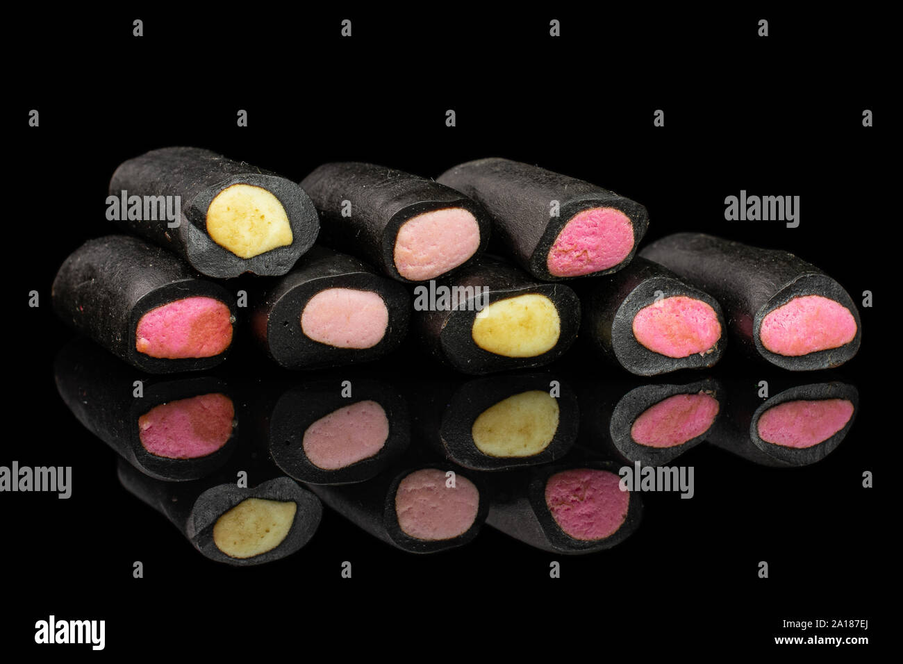 Group of eight whole sweet black liquorice candy isolated on black ...