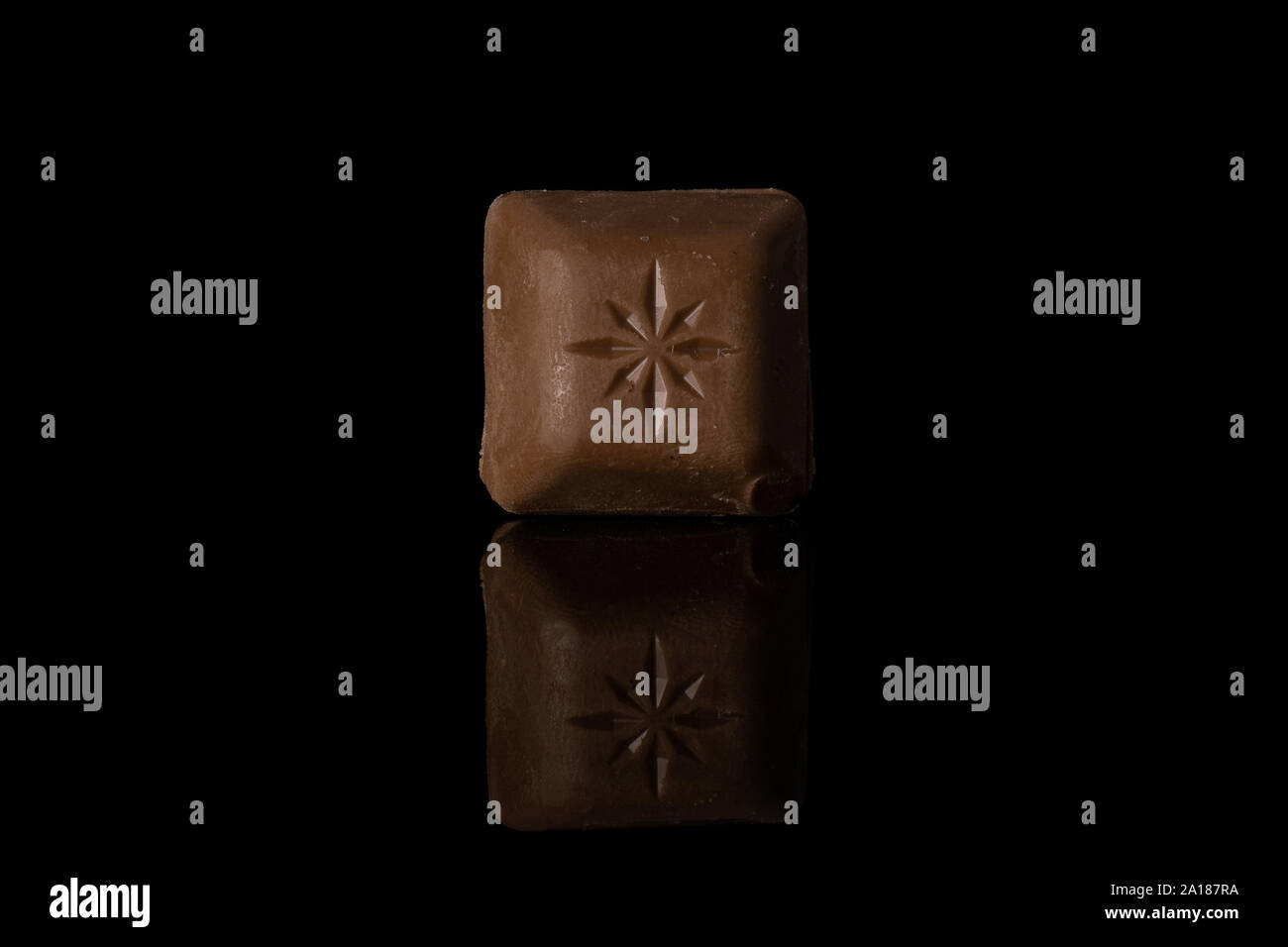 One whole fresh chocolate piece isolated on black glass Stock Photo - Alamy