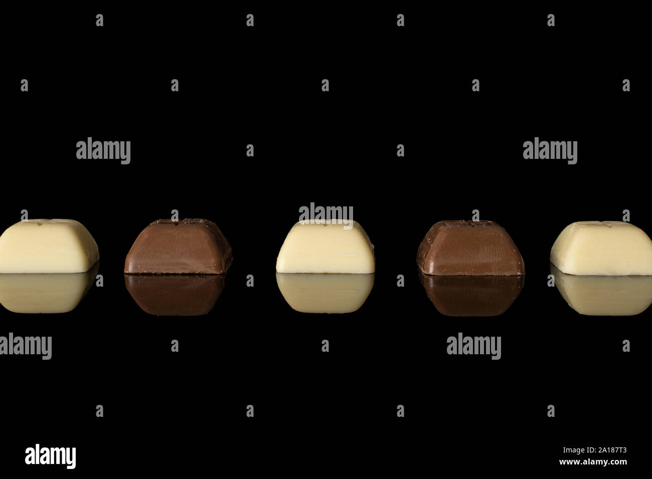 Group of five whole fresh chocolate piece in line isolated on black ...