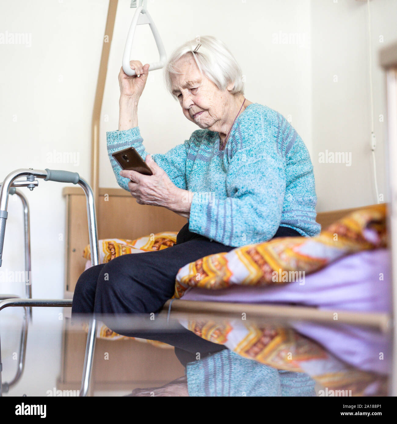 Elderly 96 years old woman reading phone message while sitting on ...