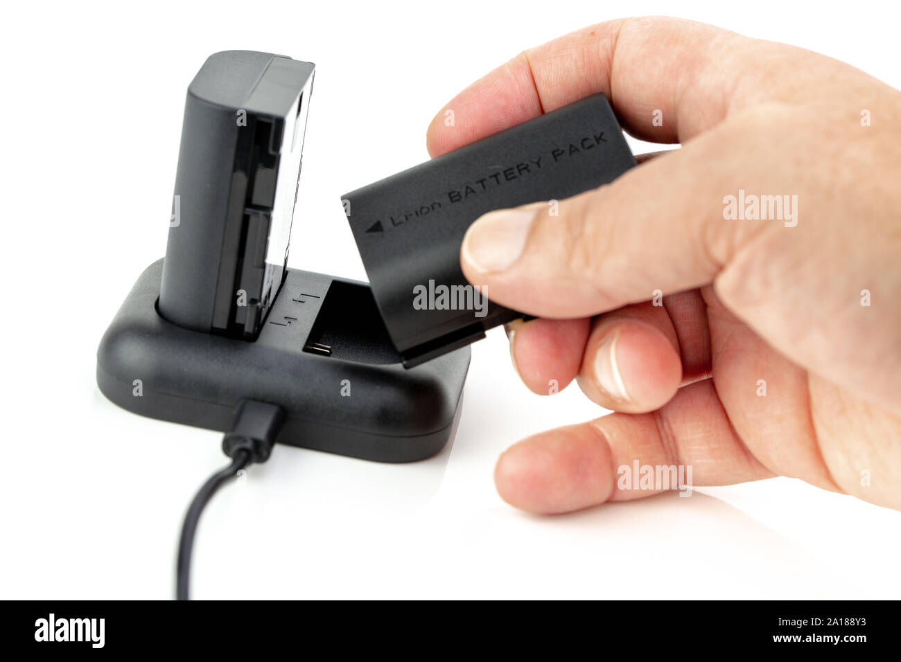 Man manipulating Camera battery and charger on white background Stock ...