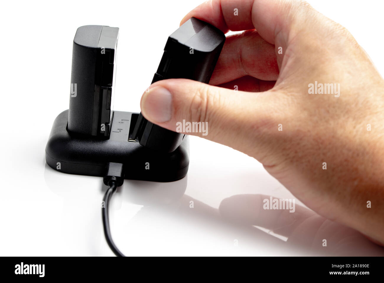 Man manipulating Camera battery and charger on white background Stock ...