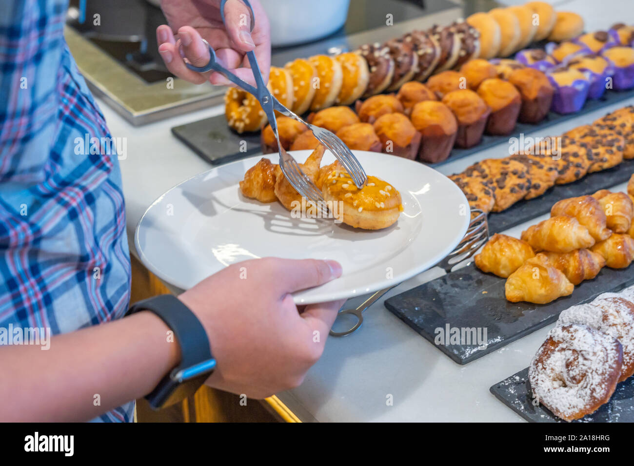 Human picking caramel donut into his plate at buffet party Stock Photo ...