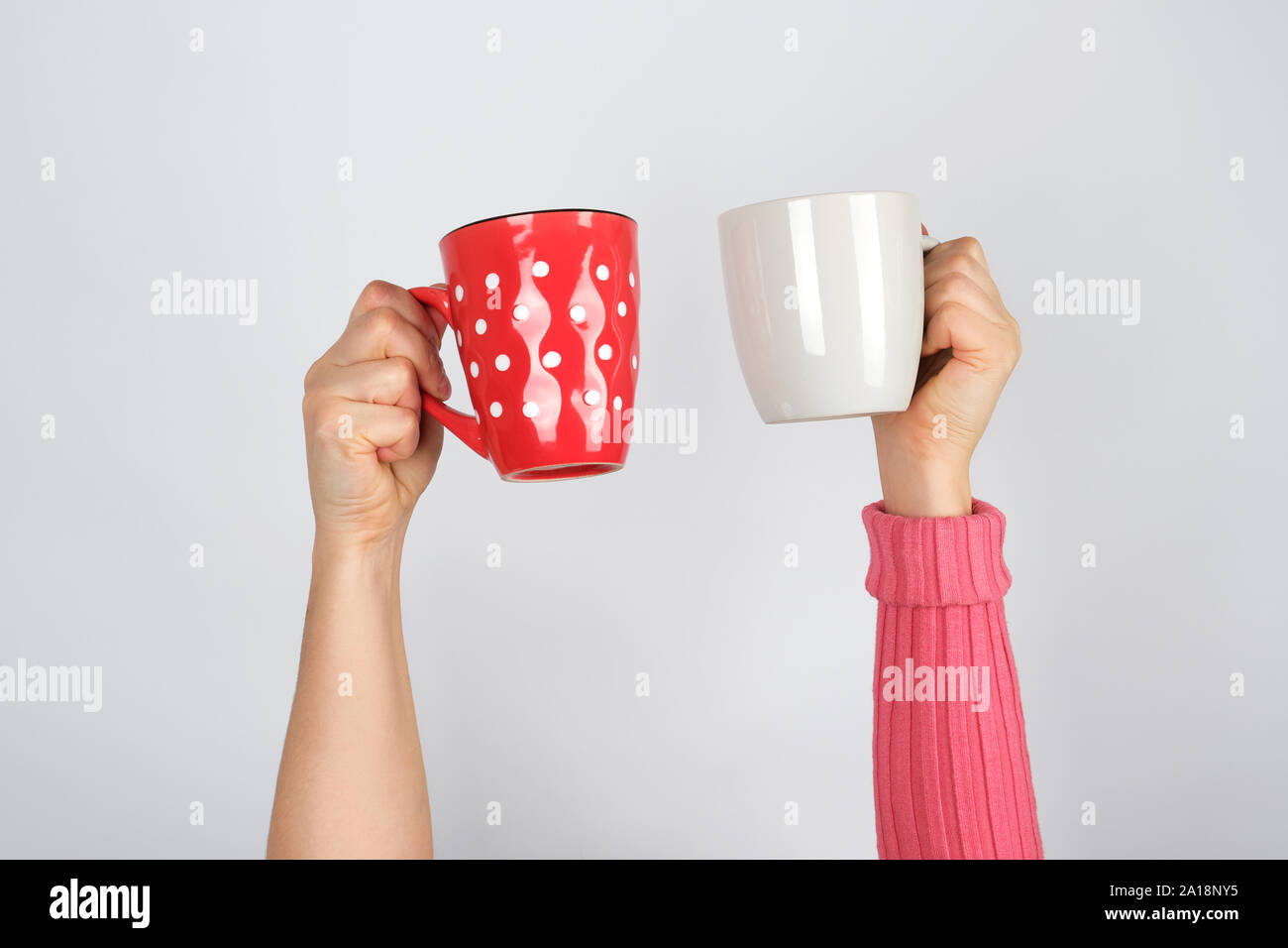 two hands holding ceramic mugs on a white background, copy space Stock ...