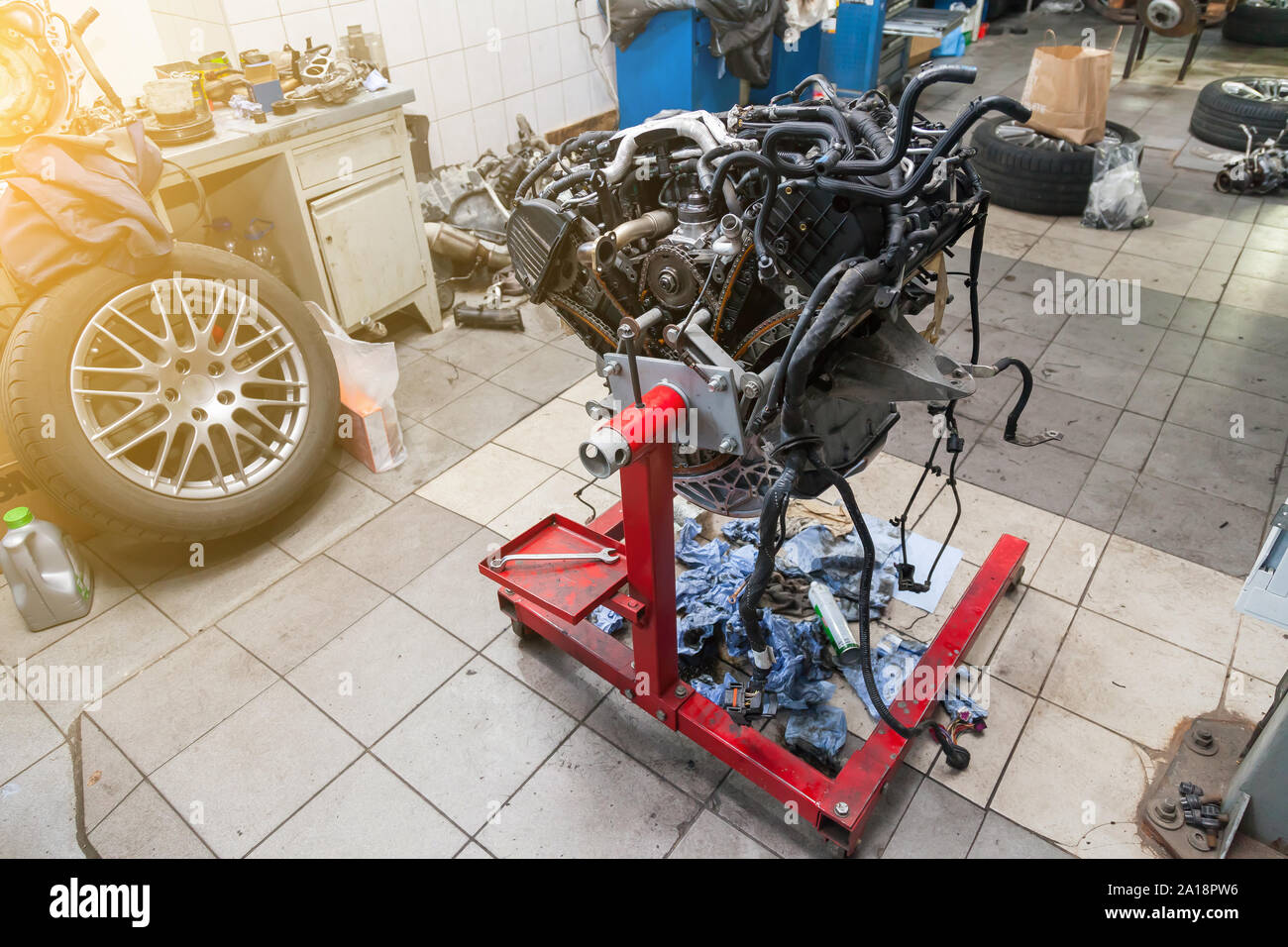 Replacement used engine mounted on a crane for installation on a car ...