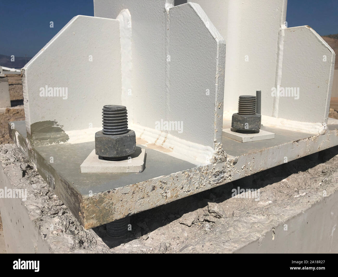 Metal pillar fastened to basement with anchor bolts and nuts ...