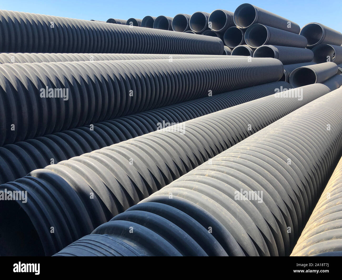 Stacked corrugated pvc-pipes at the outdoor warehouse. Drainage ...