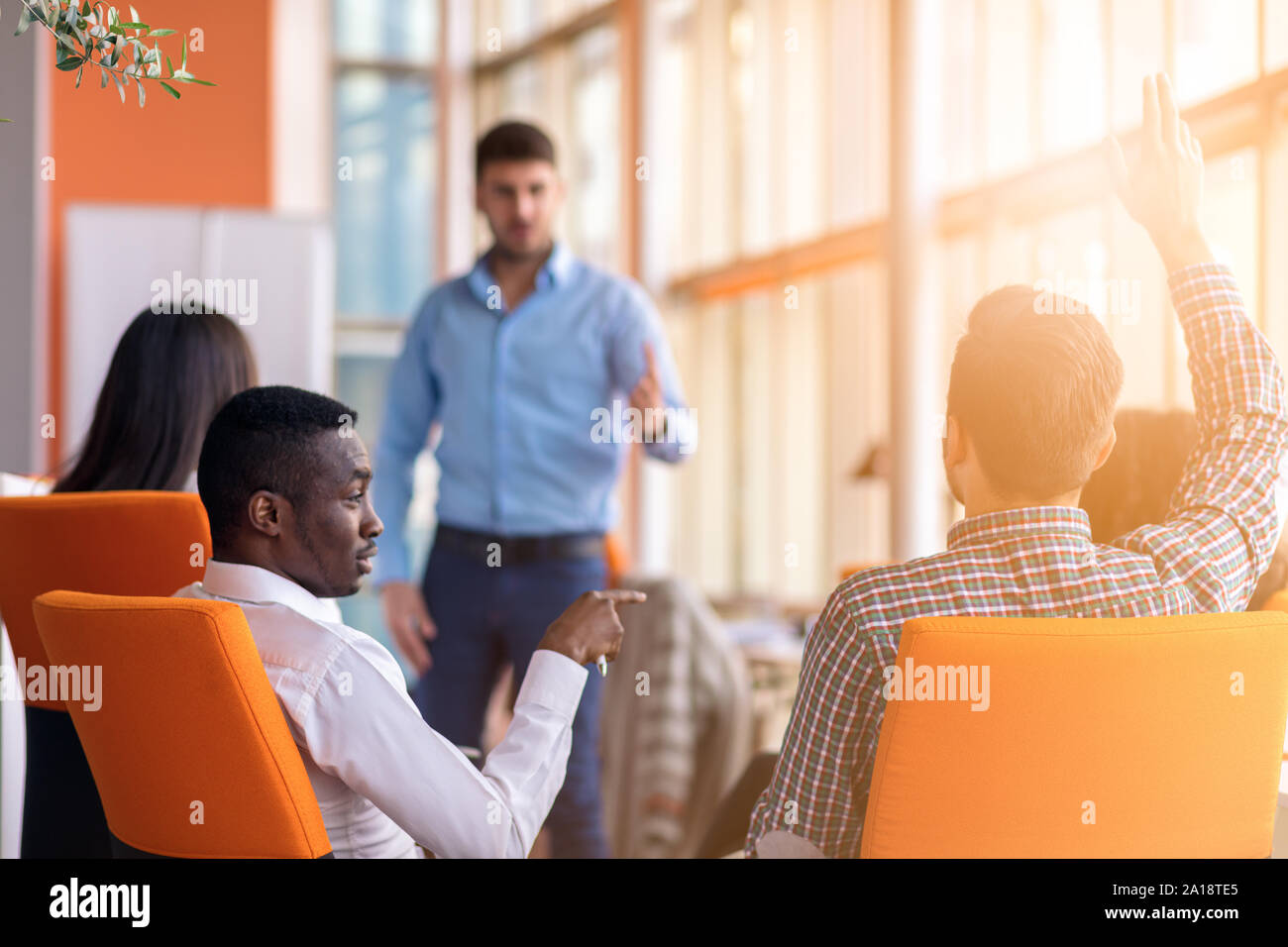 Young colleagues raising hands at the business meeting in office Stock ...