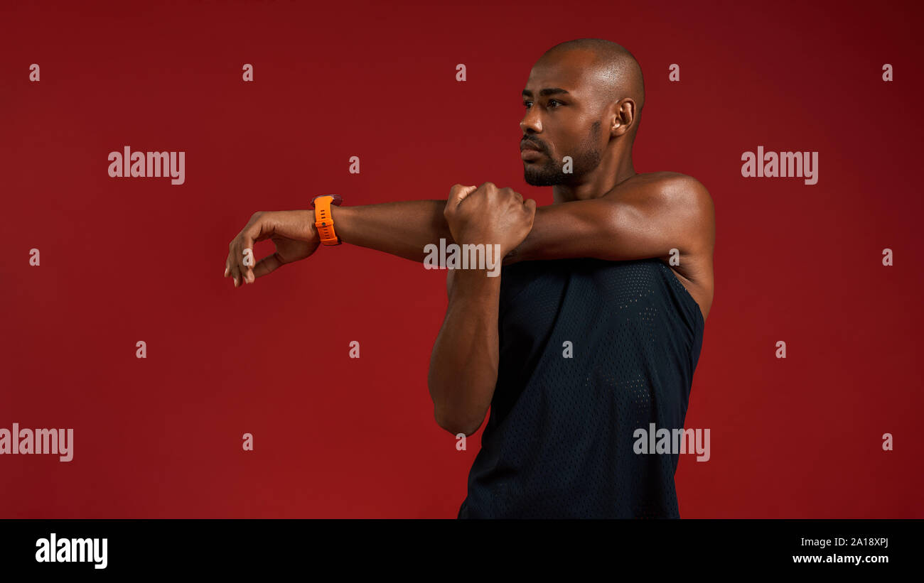 Good stretch. Confident young afro american man in sports clothing ...