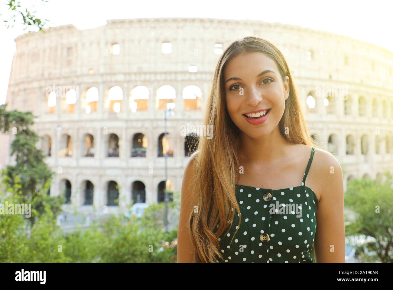 Portrait of smiling beautiful girl in Rome with Colosseum on the ...