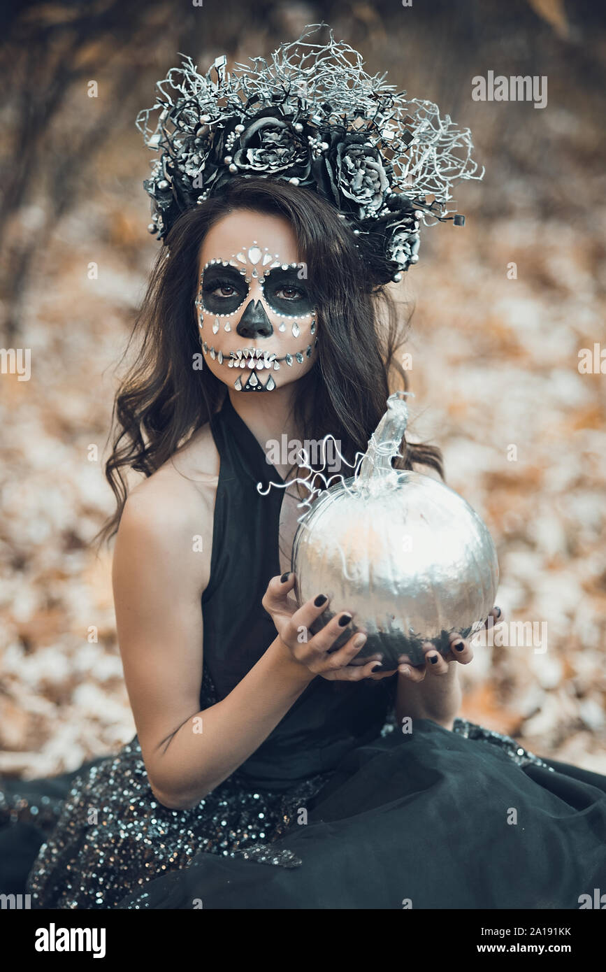 Closeup portrait of Calavera Catrina in black dress. Sugar skull makeup ...