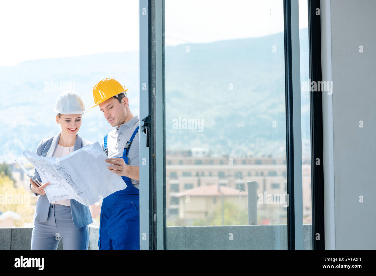 Principal and builder reading blueprints on construction site Stock ...
