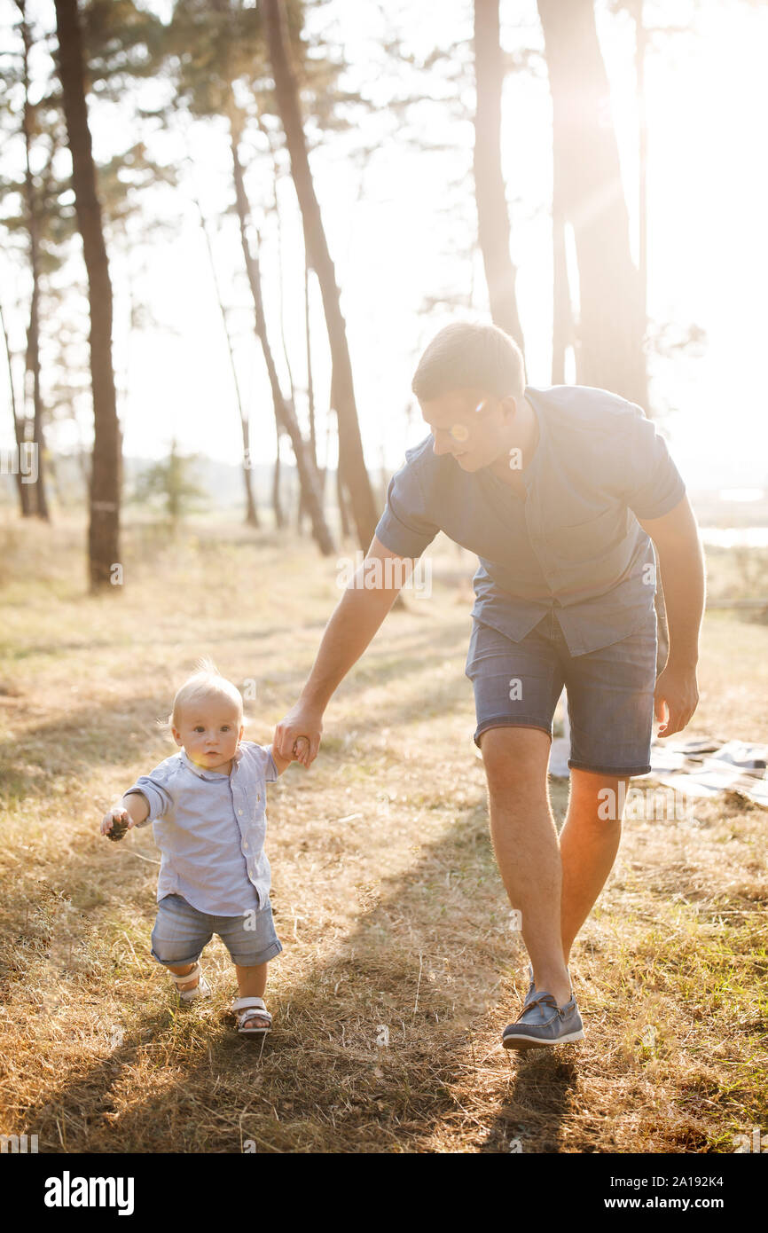 Young father walks with his cute little boy in a forest Stock Photo - Alamy
