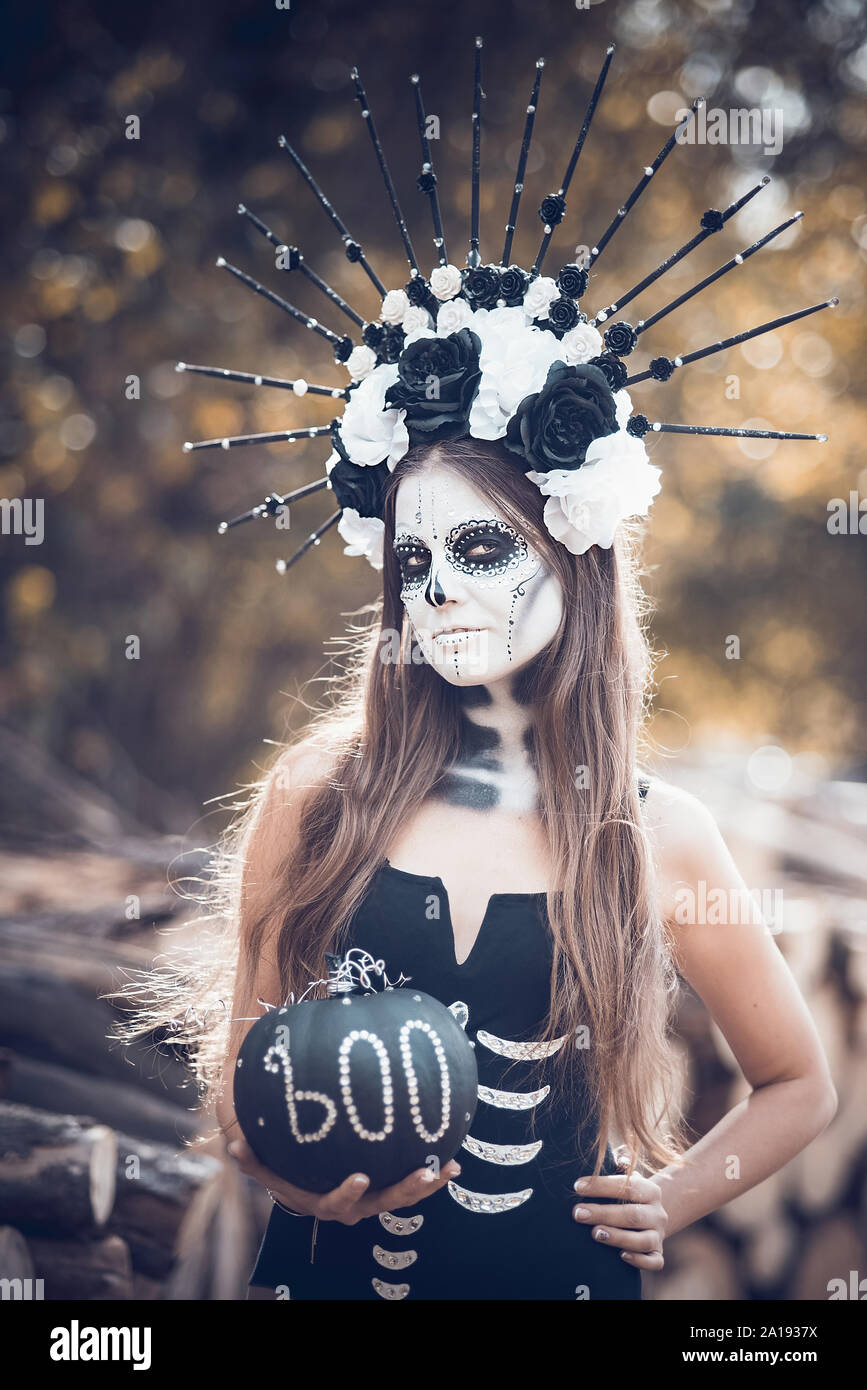 Closeup portrait of Calavera Catrina in black dress. Sugar skull makeup ...
