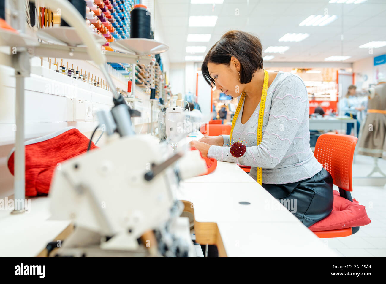 Seamstress working in her studio sewing clothes Stock Photo - Alamy