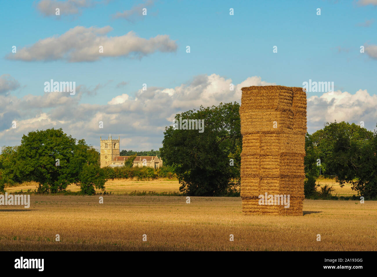 Tall hay stack and village church at Skipwith, North Yorkshire, England ...