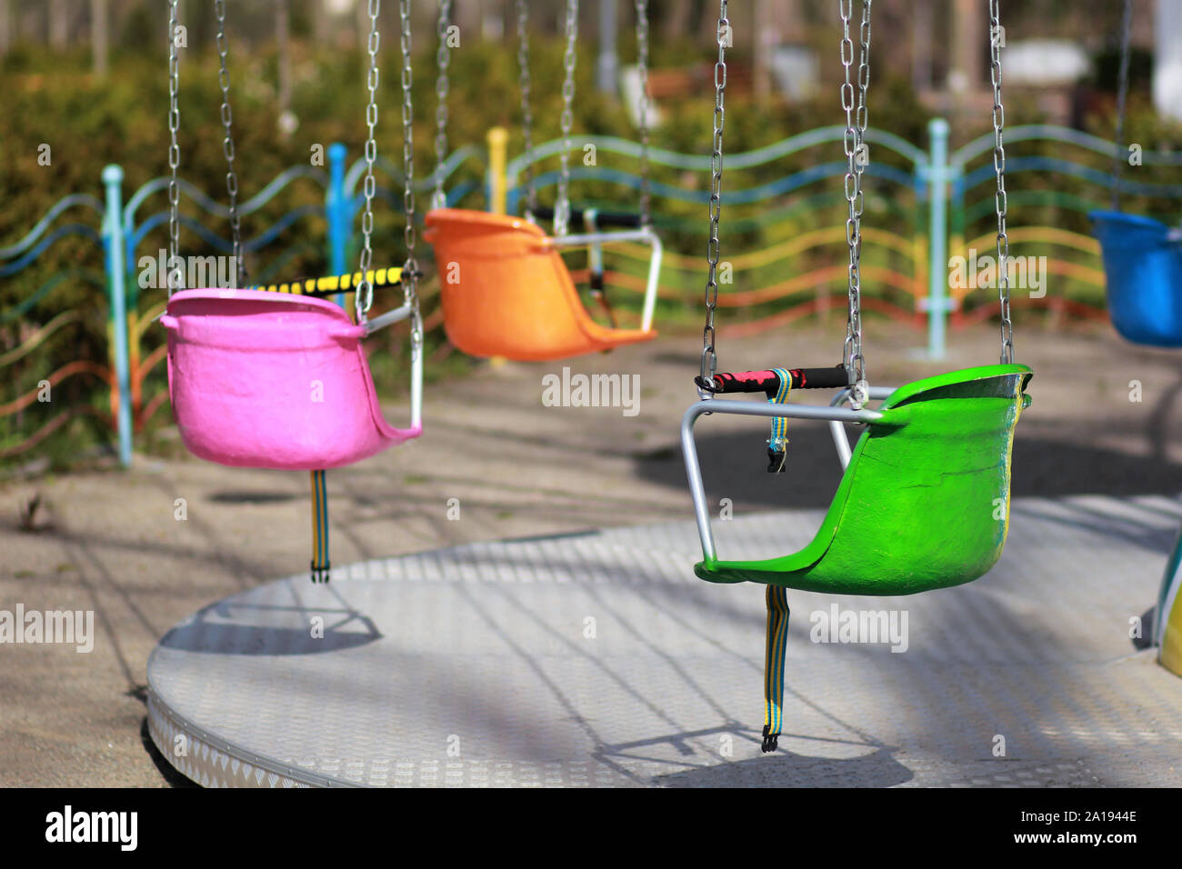 Colorful empty chain swings in the summer park Stock Photo - Alamy