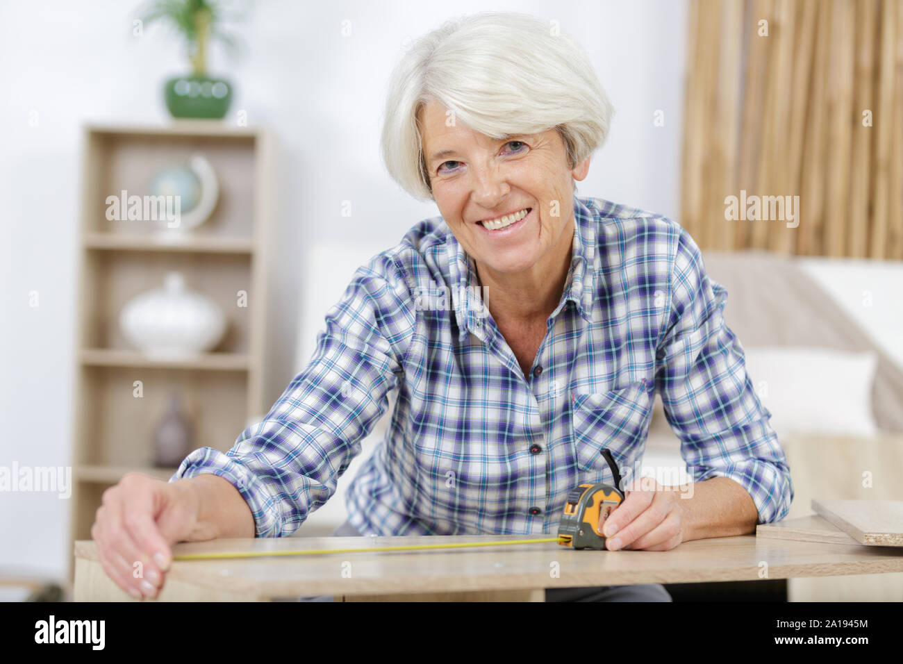 happy elderly woman measuring a furniture Stock Photo - Alamy
