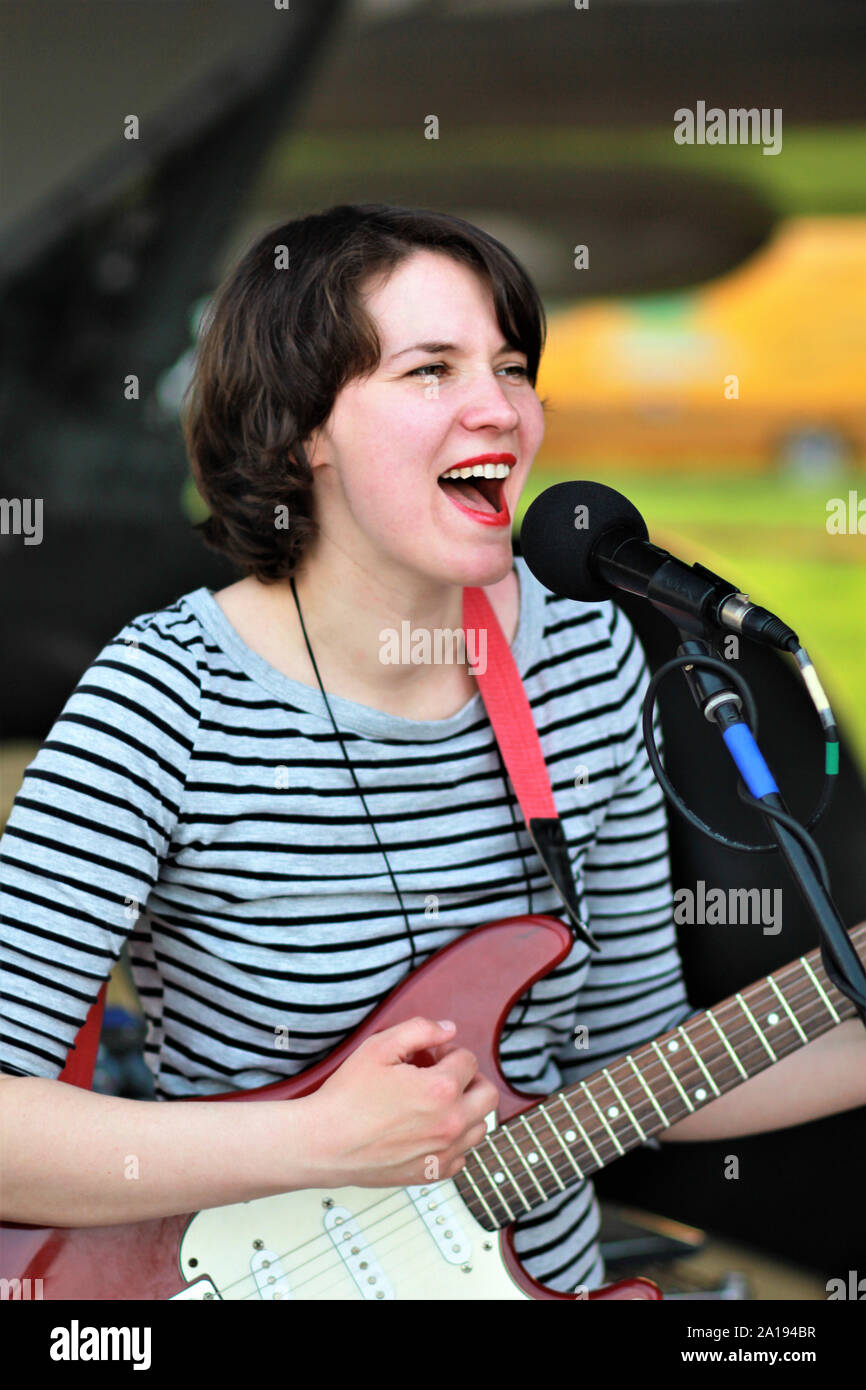 Woman singer playing electric guitar at the open air stage Stock Photo ...