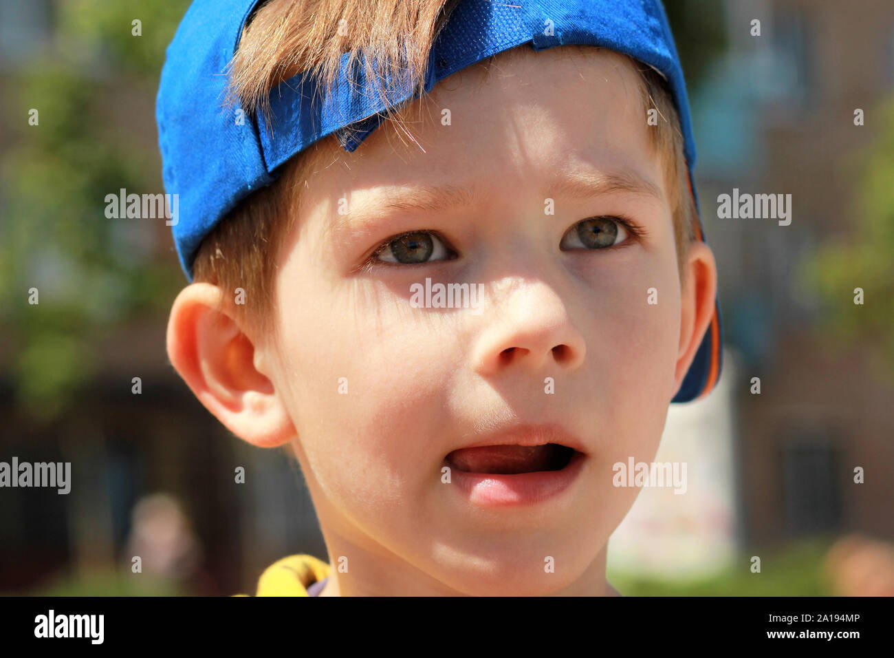 Close up portrait of a boy with serious face expression wearing blue ...