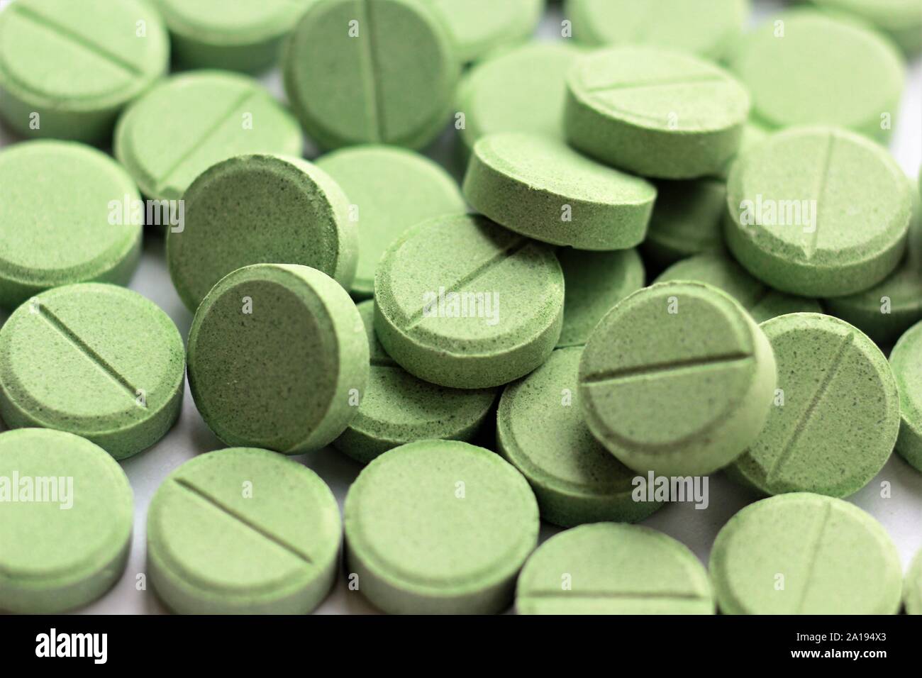 Heap of scattered mint green color medical pills tablets background ...