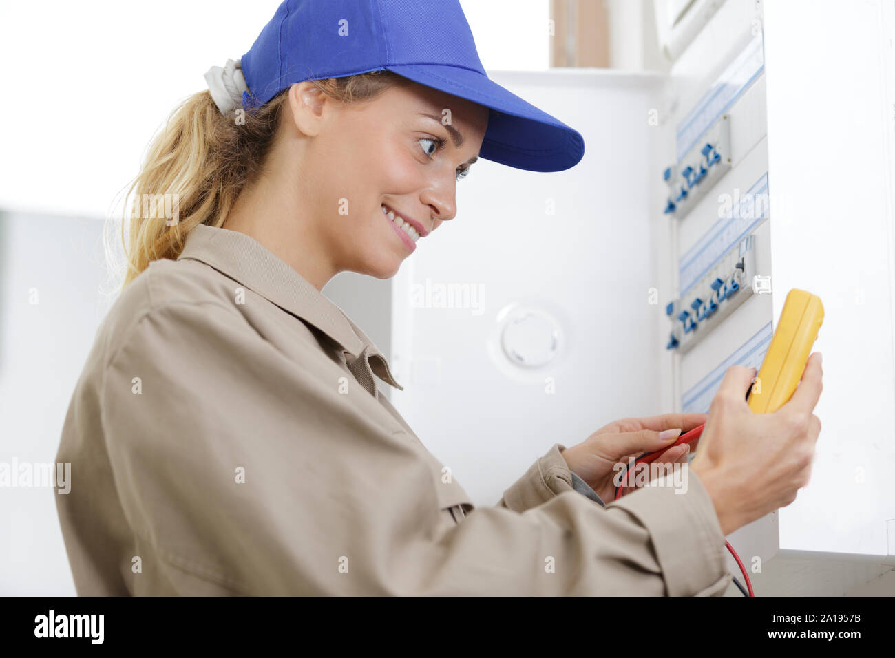 happy woman measuring electrical current Stock Photo - Alamy