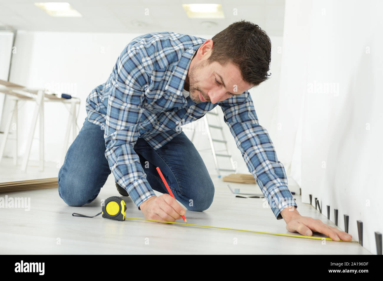 a man measuring wood floor Stock Photo - Alamy