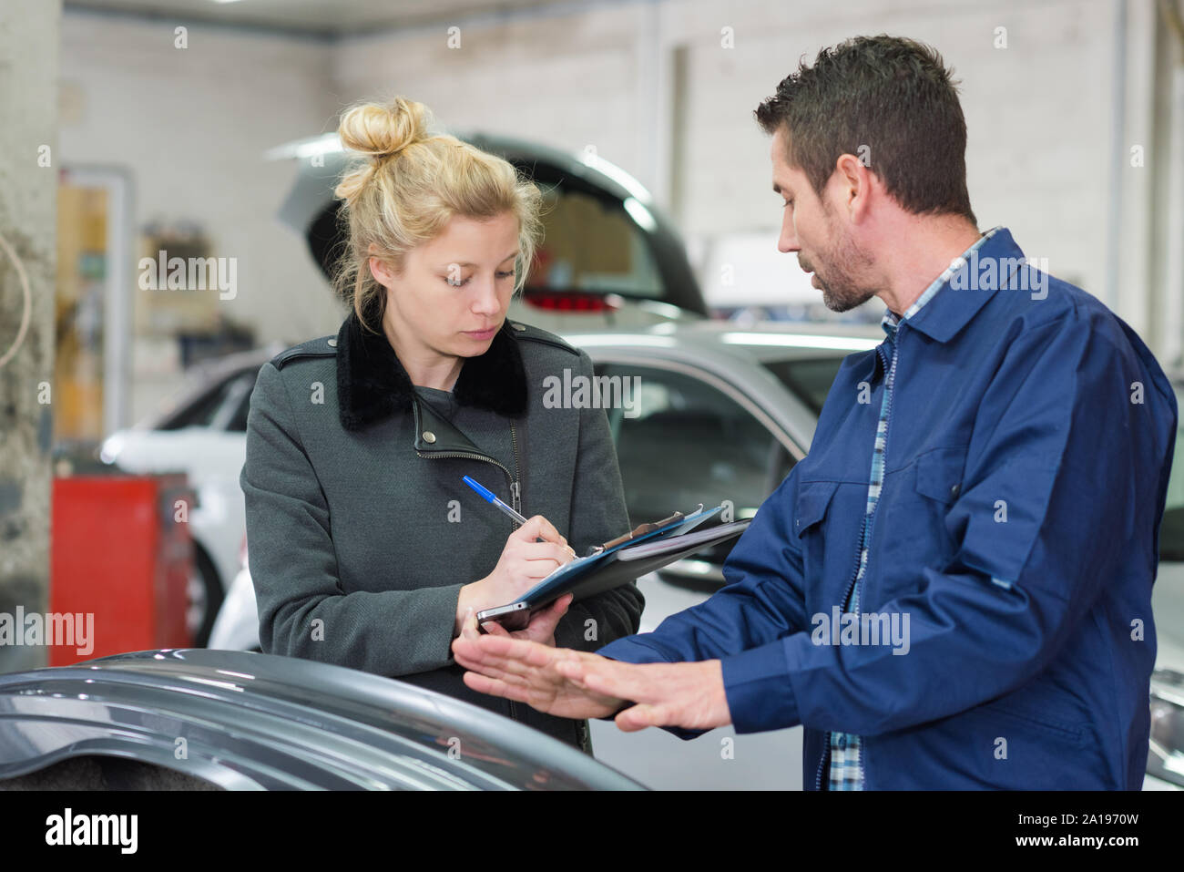 auto mechanic and female customer in garage Stock Photo - Alamy