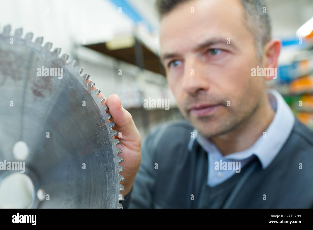 worker inspecting the blade of the circular saw Stock Photo - Alamy