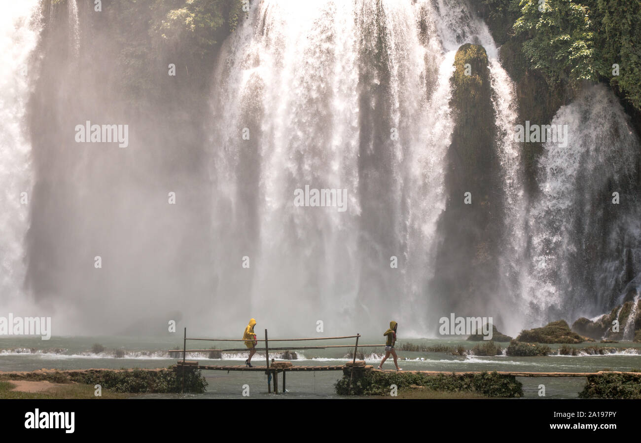 Two people walking past Ban Gioc Waterfall in Northern Vietnam Stock ...
