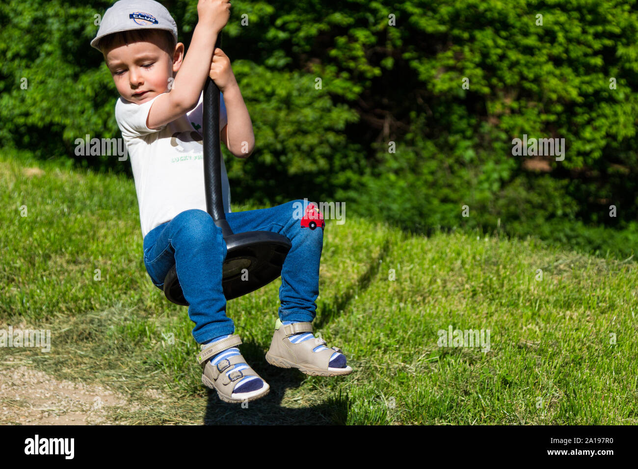 Boy child riding on zip wire at forest playground Stock Photo - Alamy