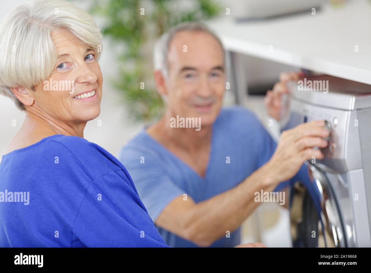 senior couple using washing machine Stock Photo - Alamy